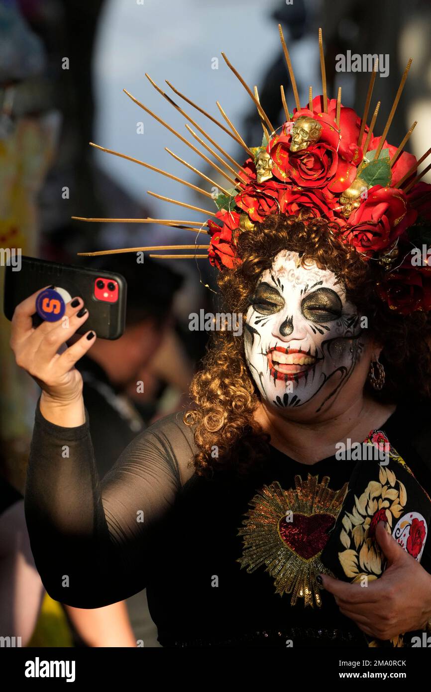 Dressed as a Catrina, Gizelle Ortiz poses for a selfie as she prepares ...