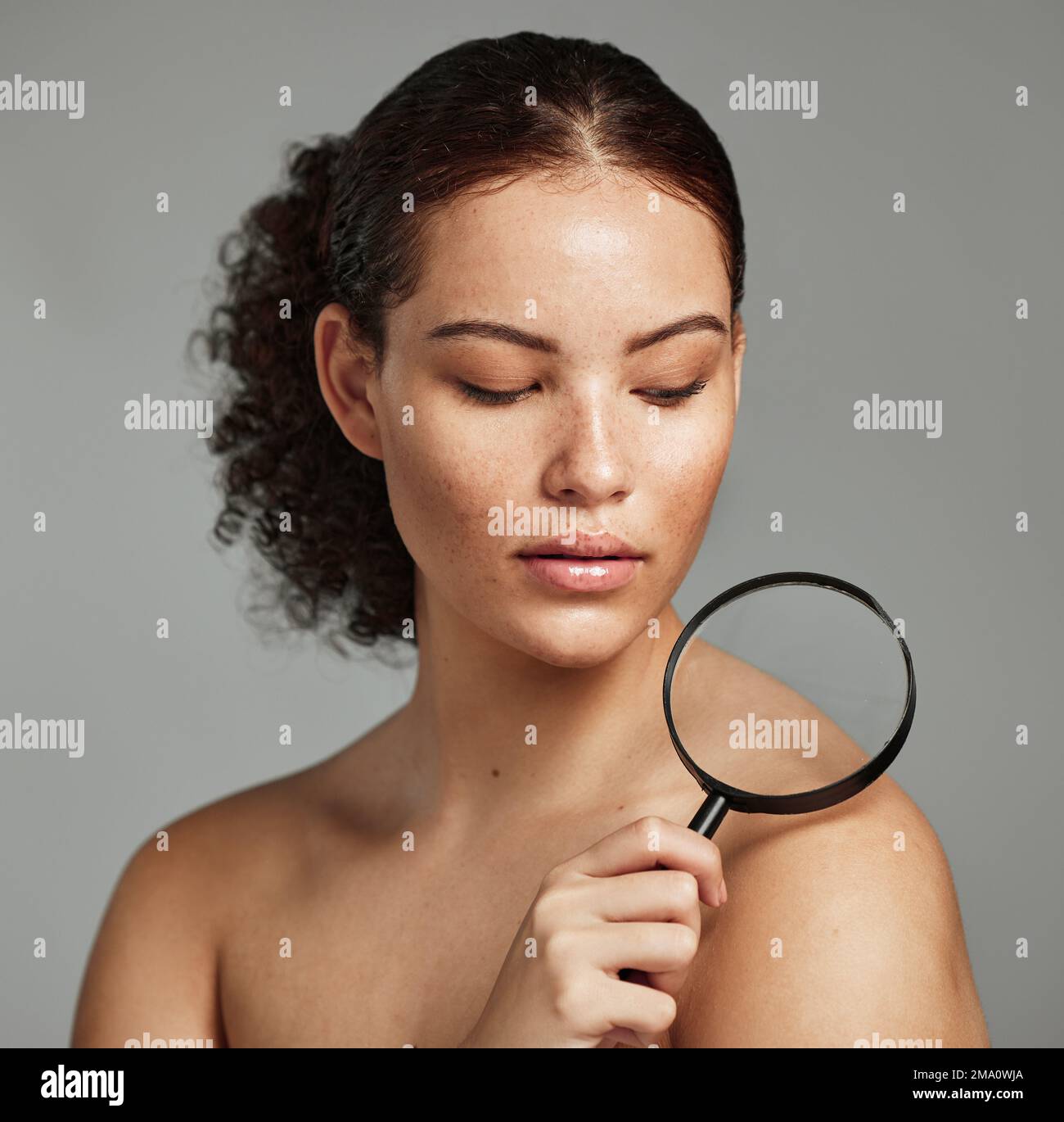 Skincare, magnifying glass and woman in studio for skin, body and ...