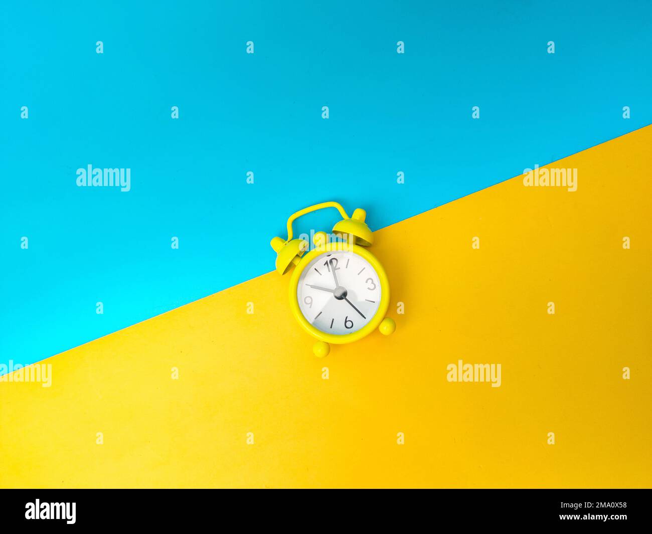 Top view yellow alarm clock on a yellow and blue background Stock Photo ...
