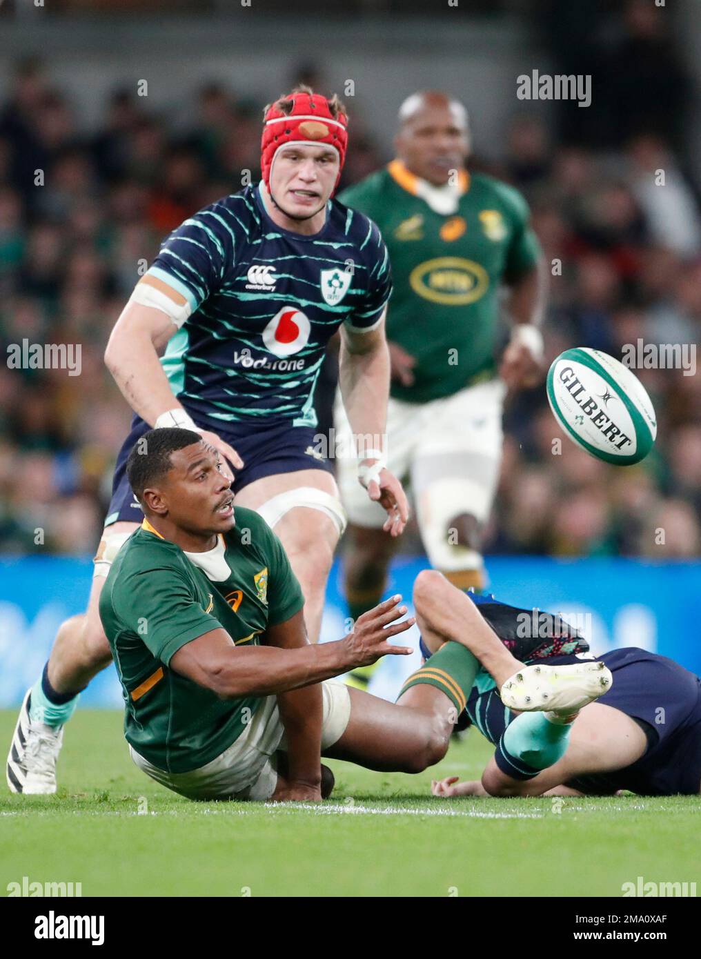 South Africa's Damian Willemse, left, passes the ball after being ...