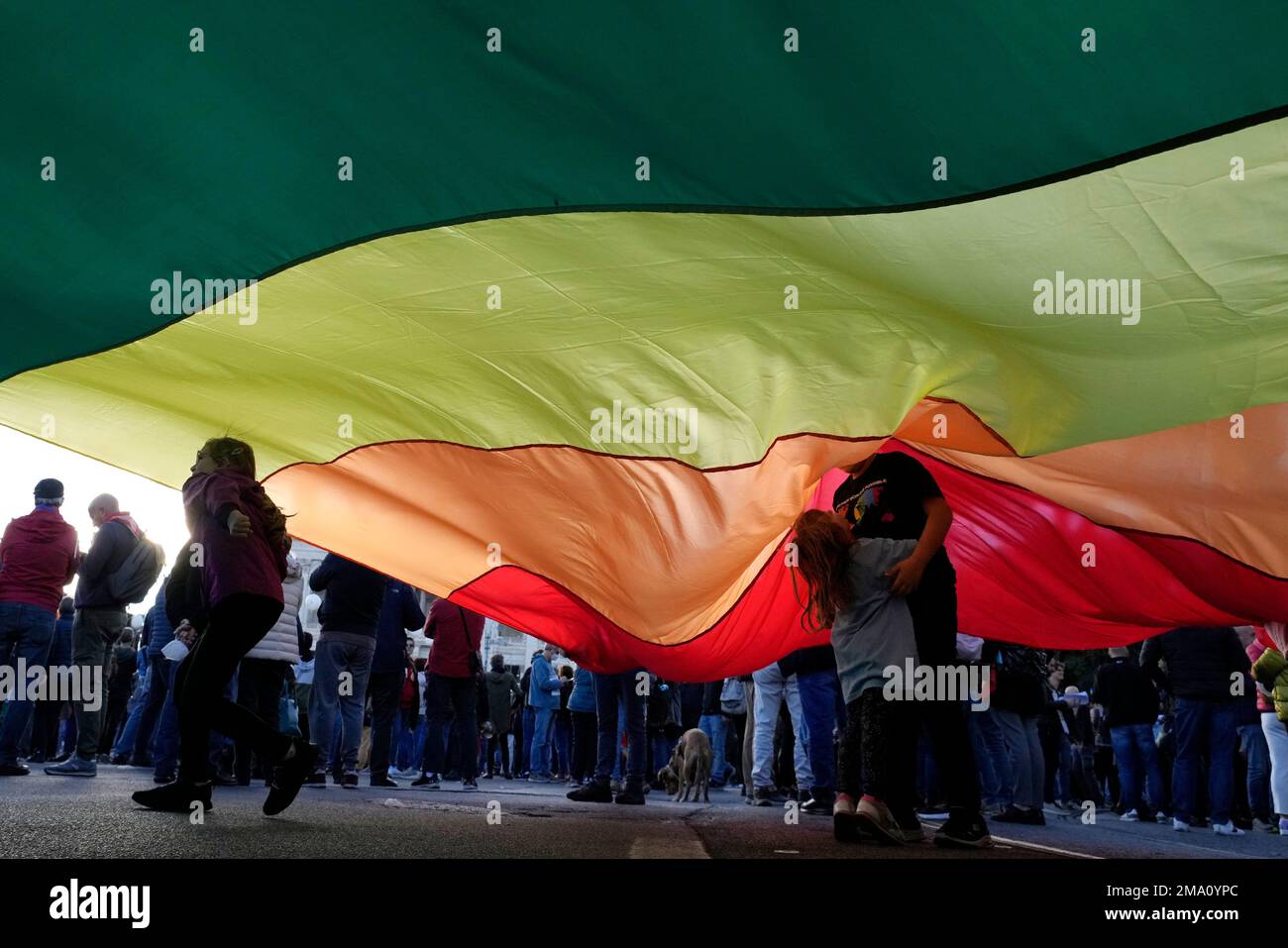 Children play under a big flag during a peace rally against war ...