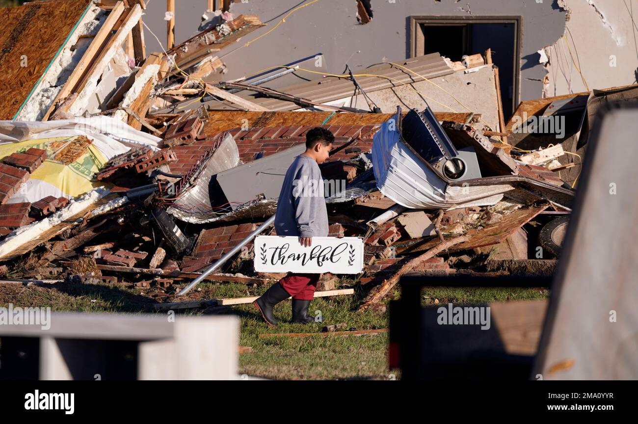 Logan Johnson, 11, carries a sign that reads "Thankful" after he ...