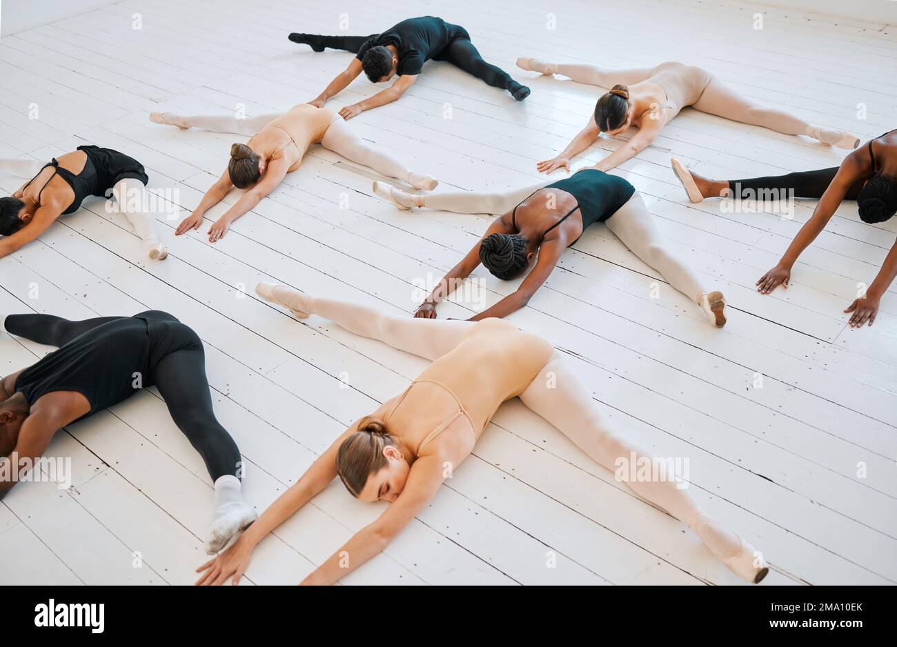 .Ballet, students and leg stretching floor together for balance, exercise and flexibility ...
