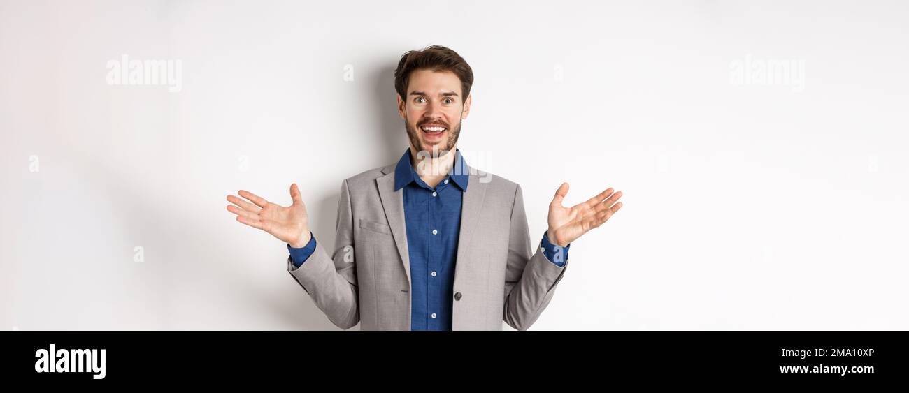 Excited male ceo manager in suit looking happy and amused, spread hands ...