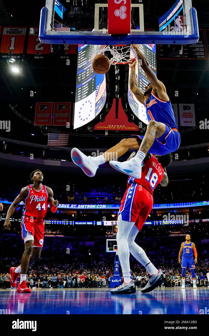 New York Knicks' Obi Toppin, top right, dunks over Philadelphia 76ers ...