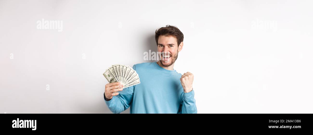 Happy man dancing with money, showing dollars and saying yes with ...
