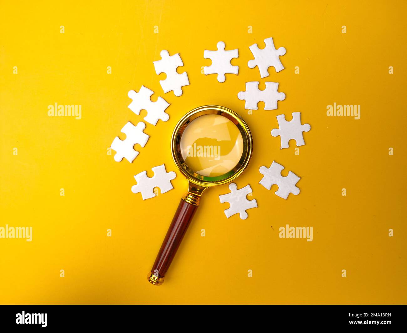 Magnifying glass searching missing puzzle on yellow background Stock ...