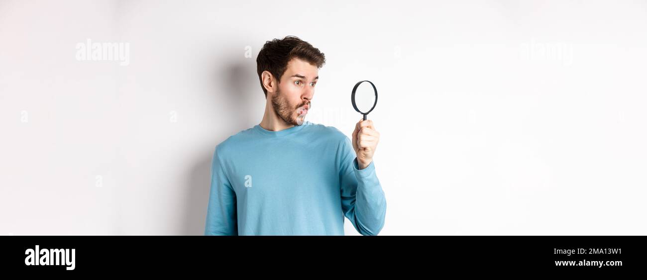 Man got surprised while looking through magnifying glass, saying wow at ...