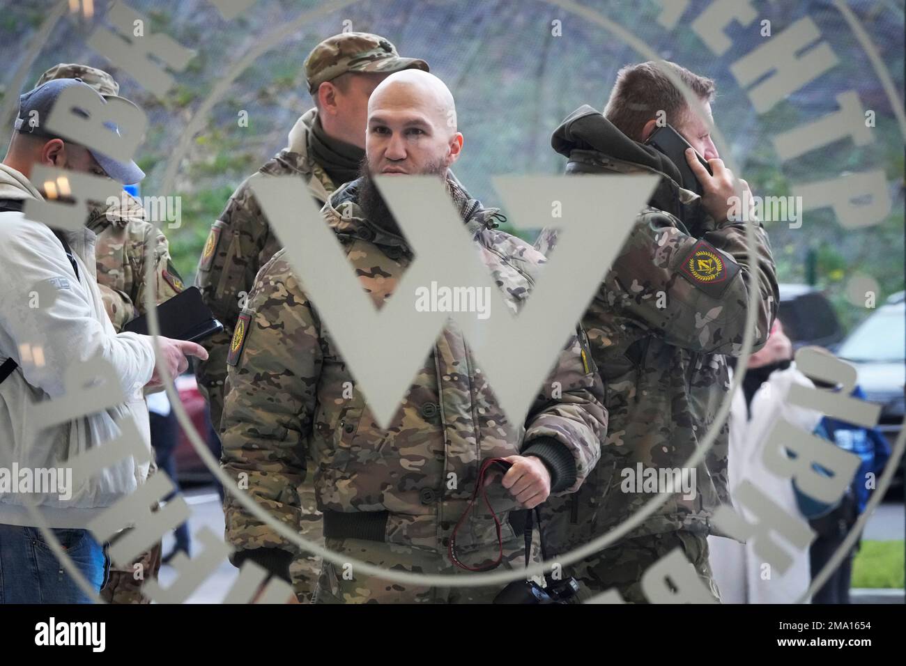 Visitors wearing military camouflage stand at the entrance of the 'PMC ...