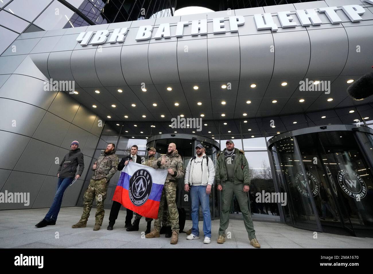 Visitors wearing military camouflage pose at the entrance of the 'PMC ...