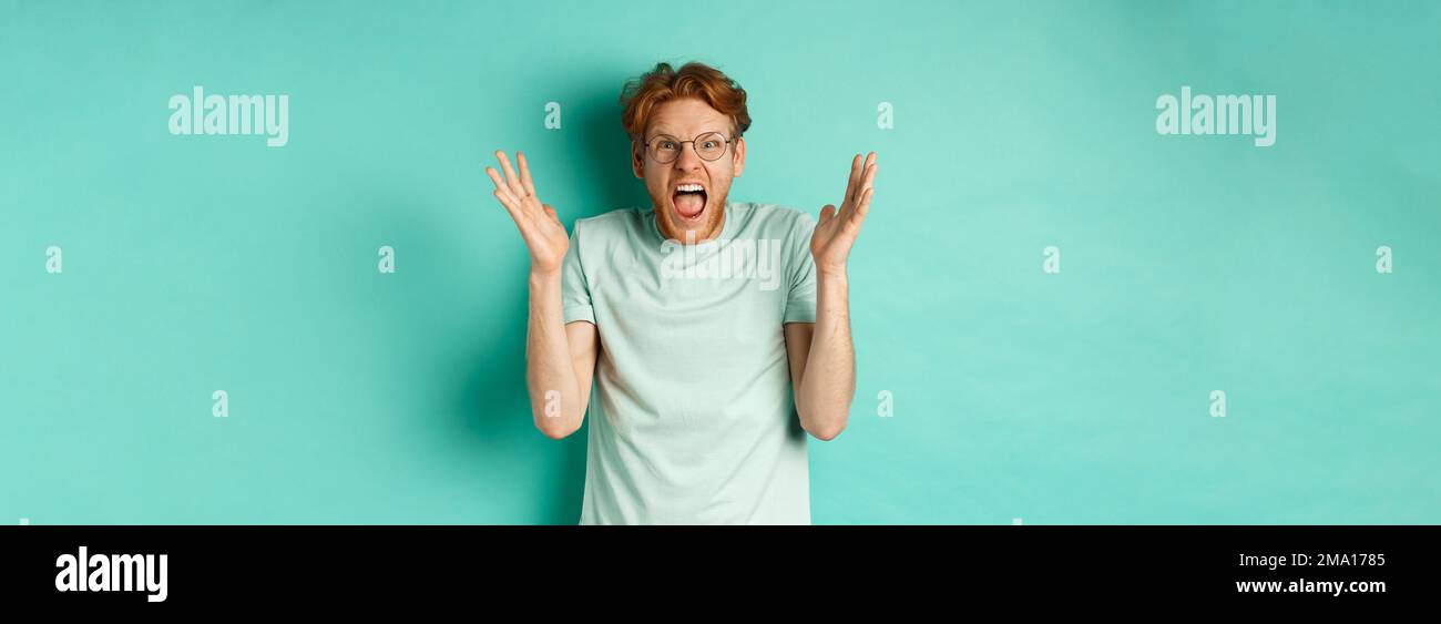 Portrait of distressed and angry redhead guy losing temper, shouting ...