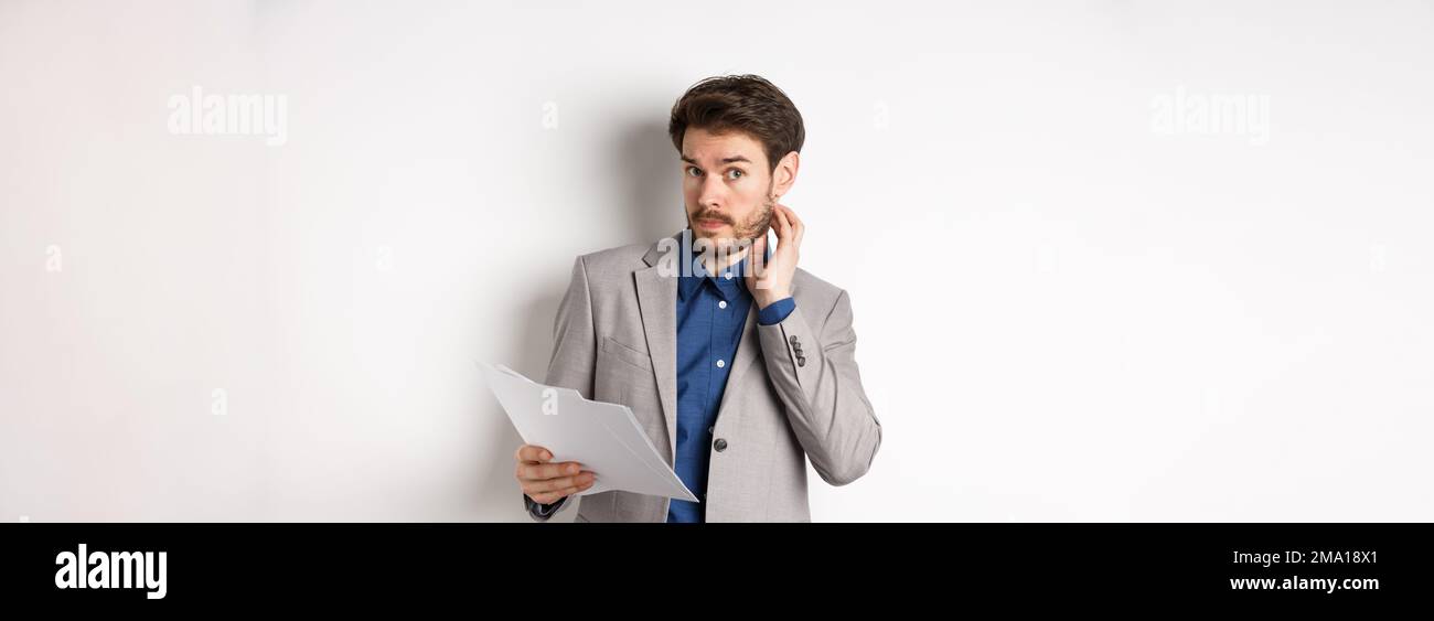 Confused office worker in suit scratching beard and look clueless, cant ...