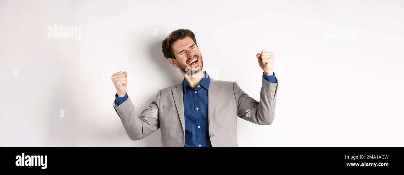 Successful business man in suit winning prize, shouting yes with ...