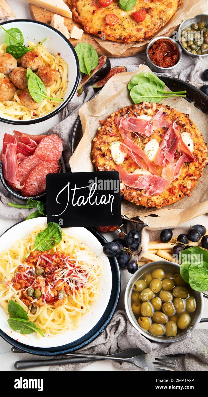 Full table of italian meals on plates and board - Pizza, pasta ...