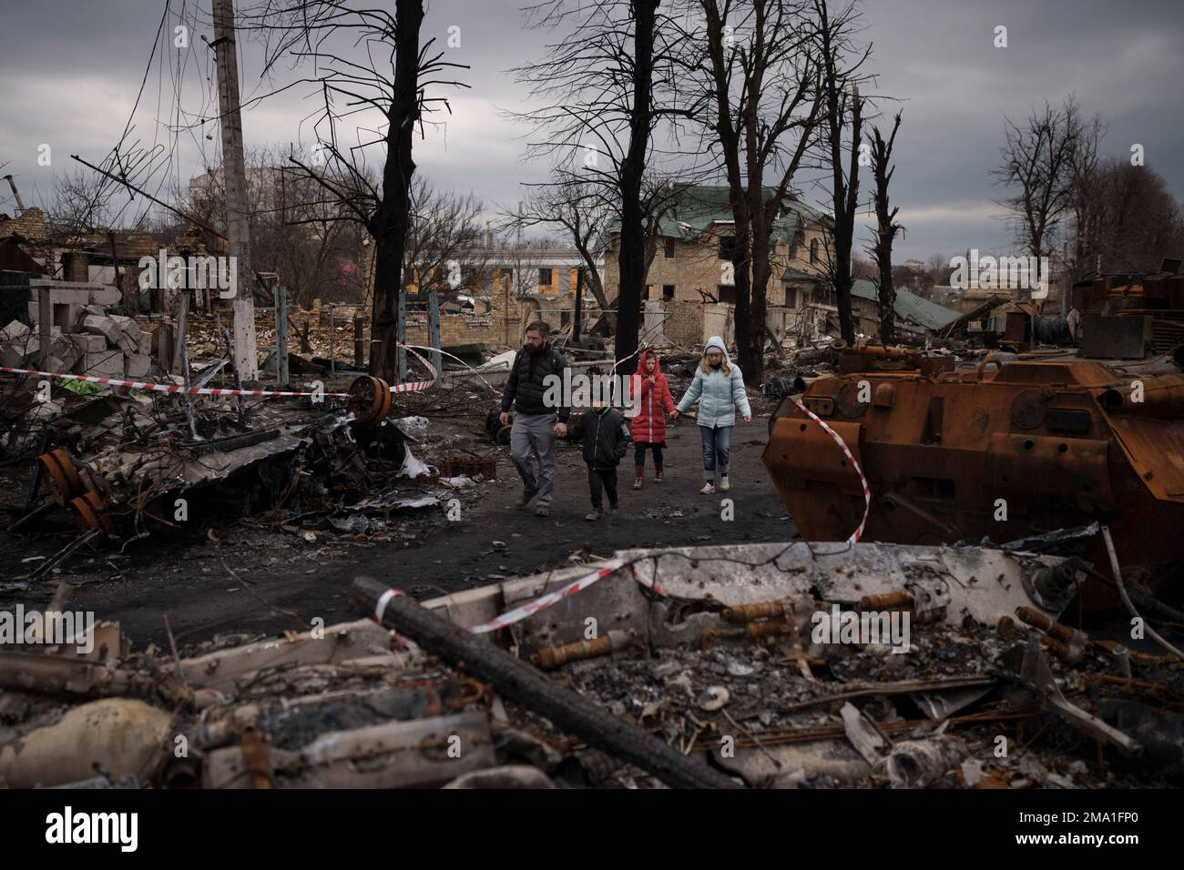 FILE - A family walks amid destroyed Russian tanks in Bucha, on the ...