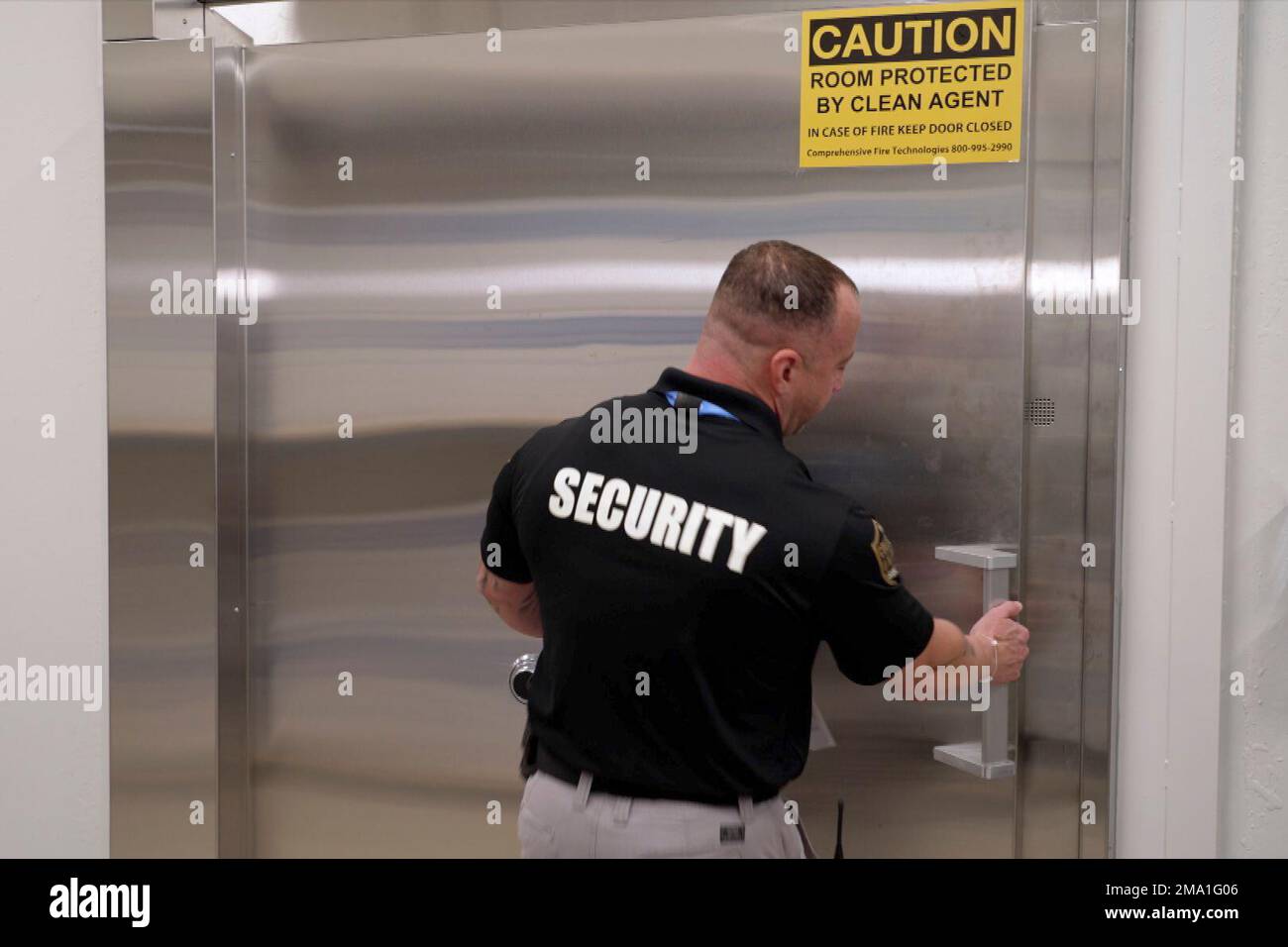 A security guard opens a steel door leading into a vault containing ...