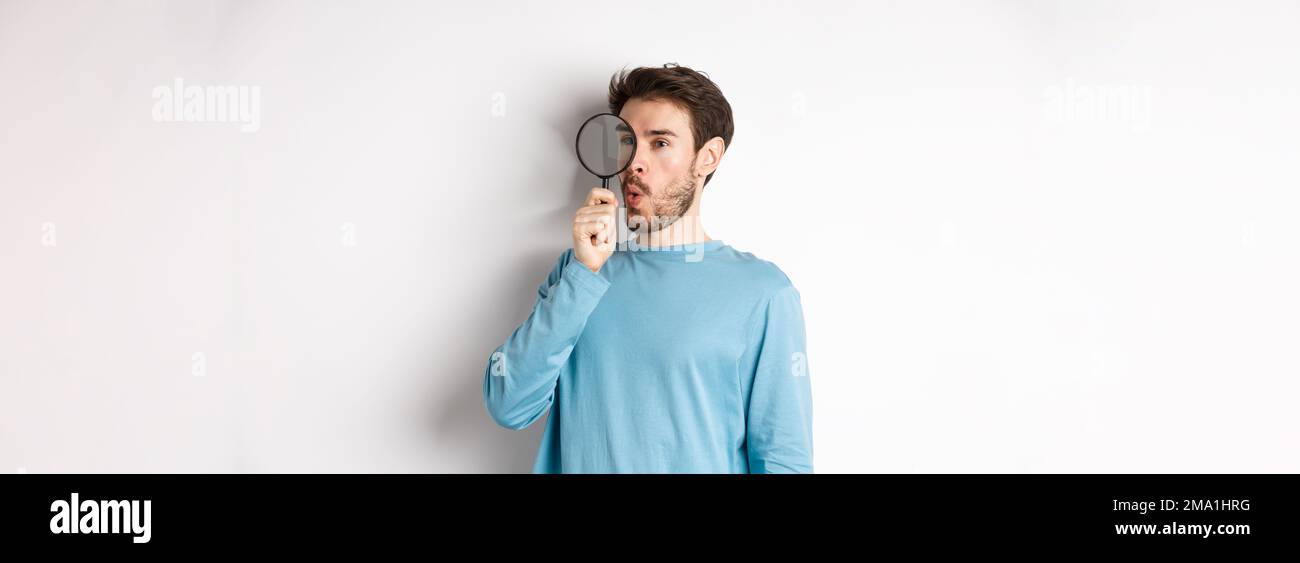 Curious guy looking through magnifying glass on right logo, saying wow ...