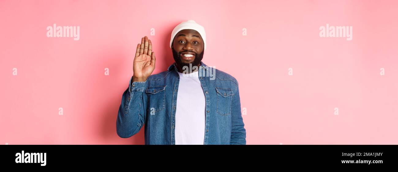 Friendly smiling Black man saying hello, waving hand, greeting you ...