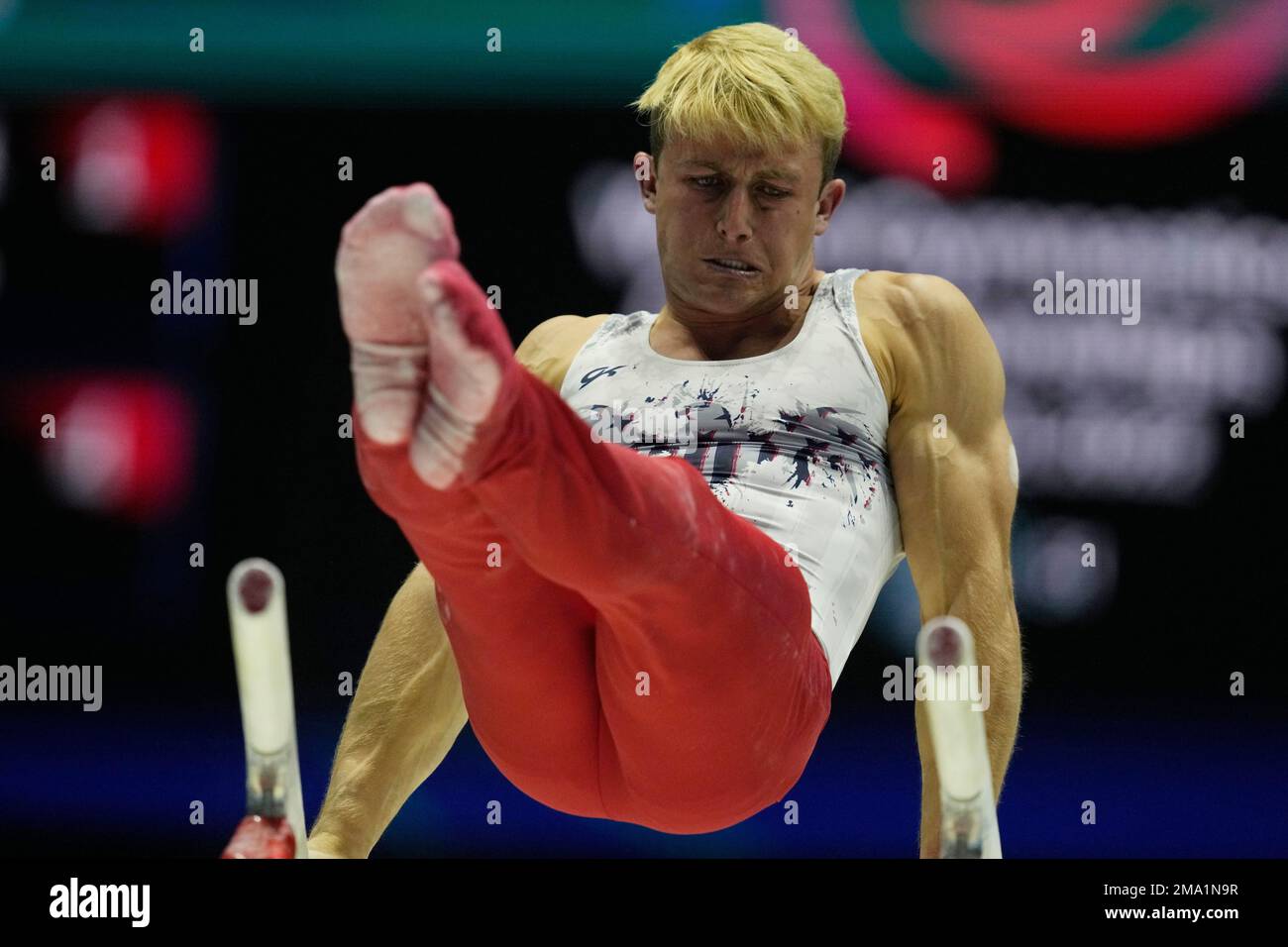 Colt Walker of the U.S. competes on the parallel bars at the Men's Team ...