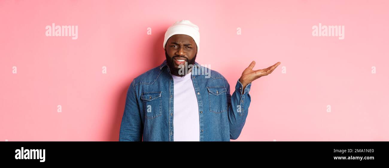 Annoyed and confused Black man arguing, raising hand up and staring at ...