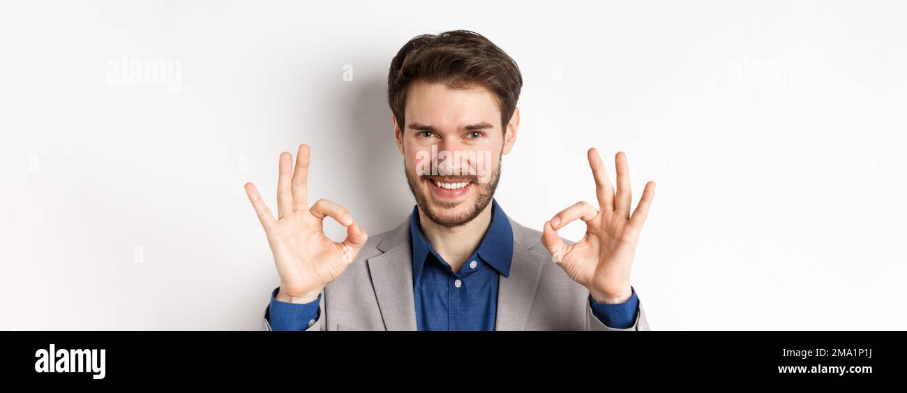 Smiling businessman in suit showing okay signs in approval, guarantee ...