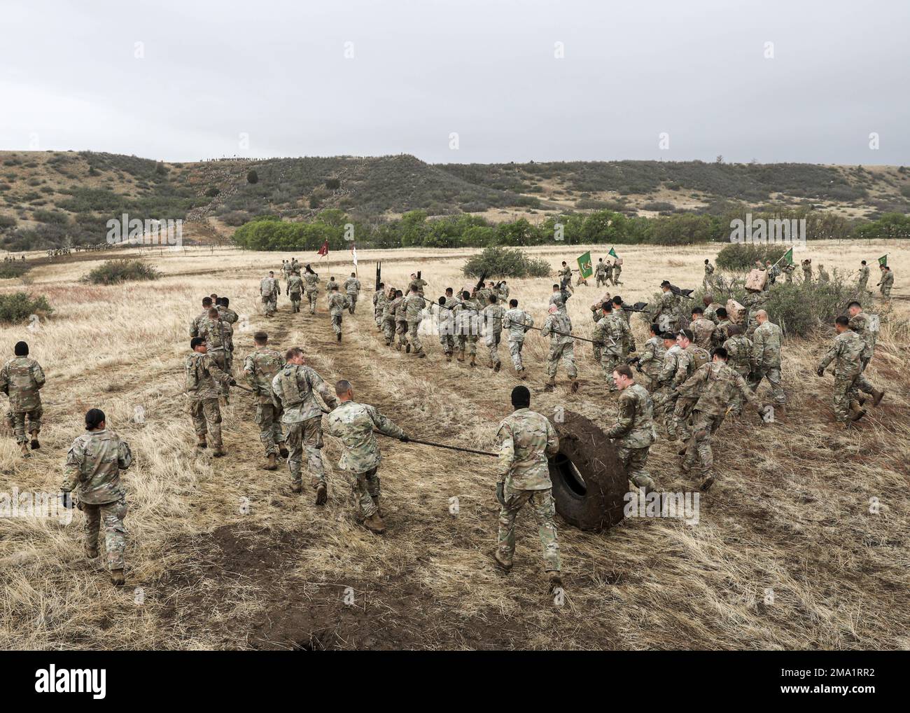 Soldiers assigned to the 4th Infantry Division roll a tire across the ...