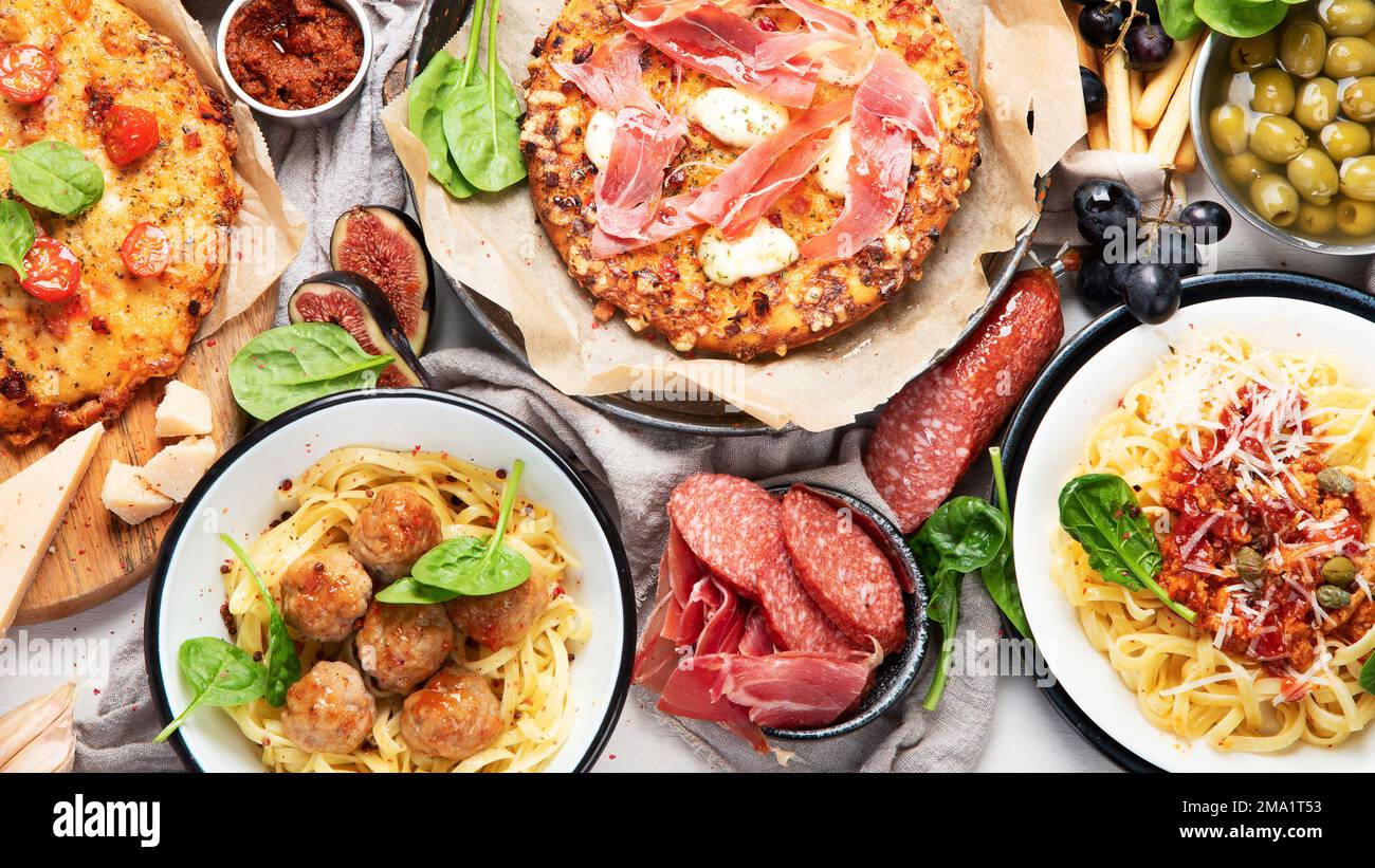 Full table of italian meals on plates and board - Pizza, pasta ...