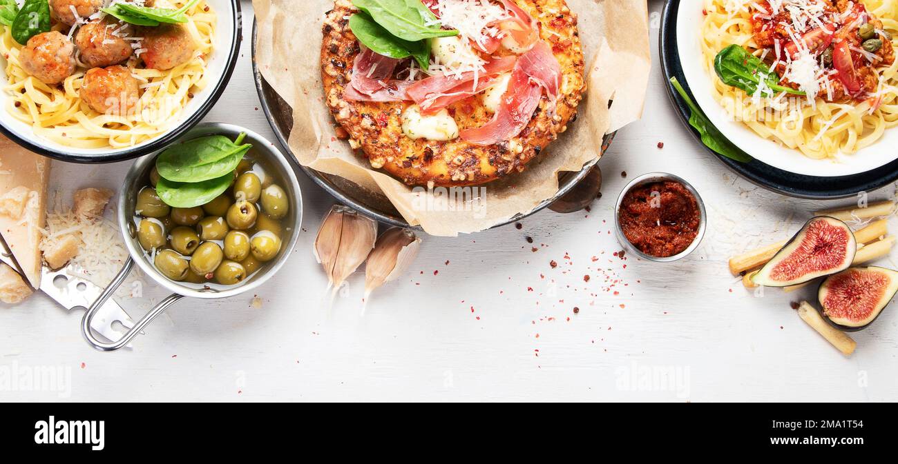 Full table of italian meals on plates and board - Pizza, pasta ...