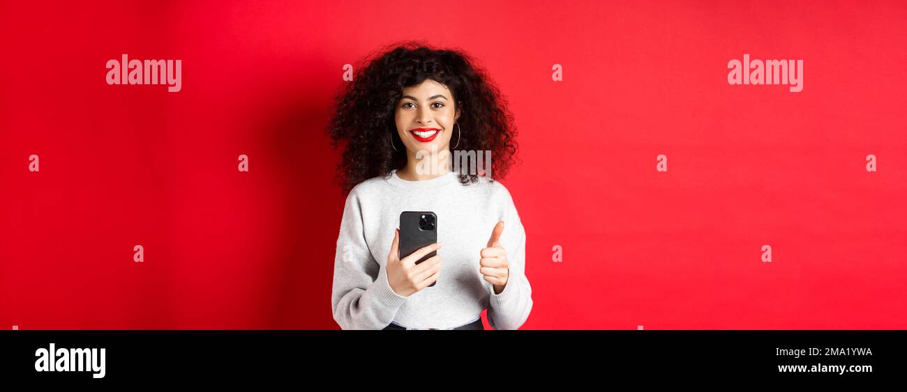Smiling european woman looking happy and satisfied, using mobile phone ...