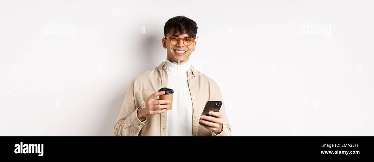 Natural handsome man in glasses drinking coffee from paper cup and ...