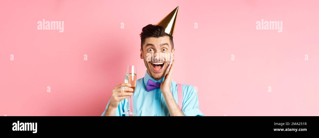 Holidays and celebration concept. Funny young man in birthday hat ...