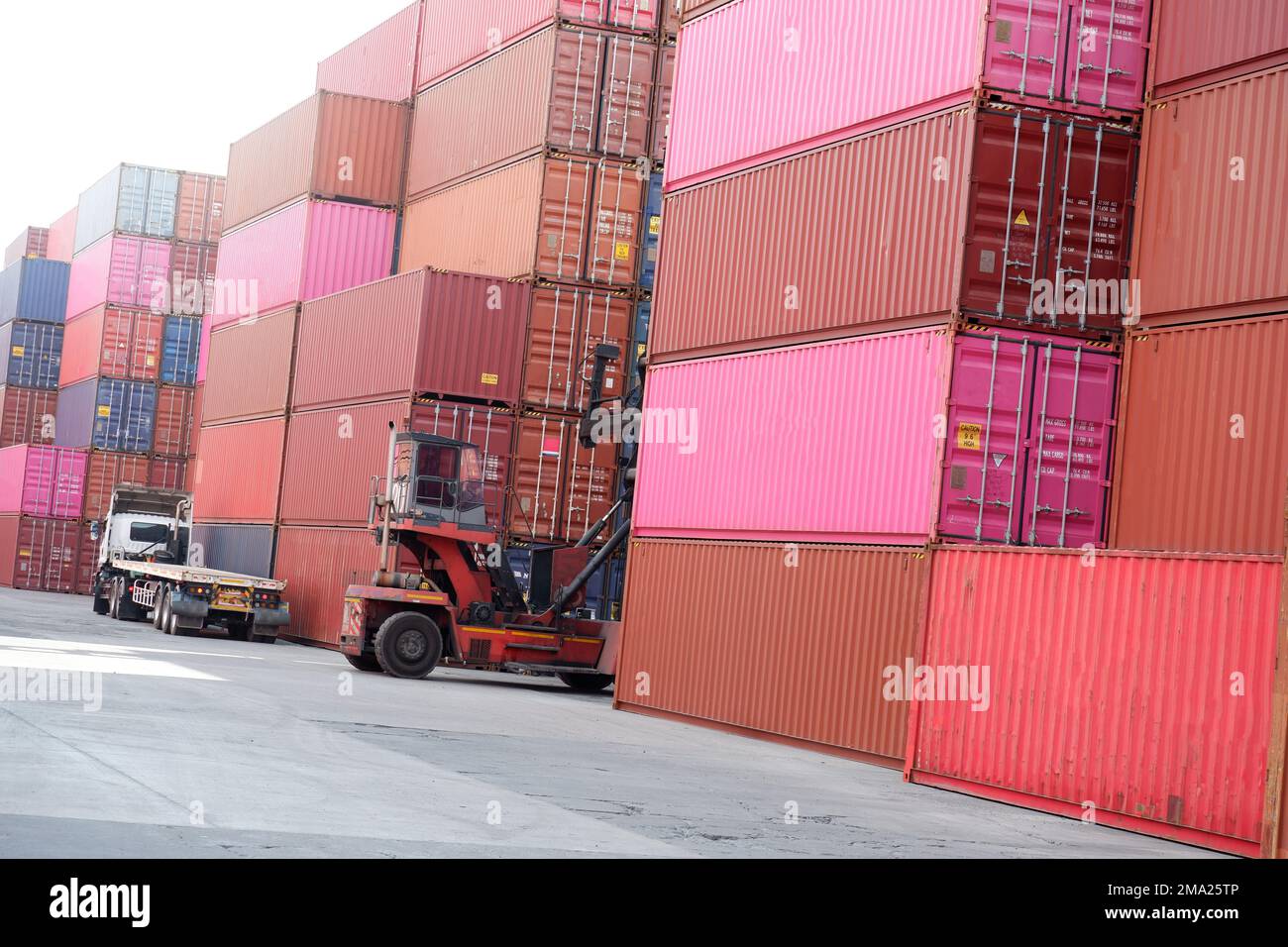 Trucks and container lifters in the container yard Stock Photo - Alamy