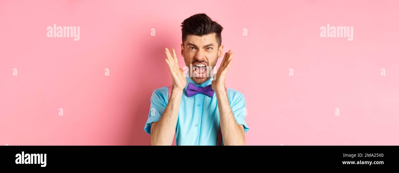 Angry man screaming like crazy, shaking hands and stare furious at ...