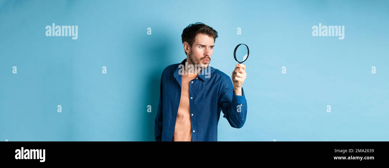 Serious man investigating or searching for something, look through ...