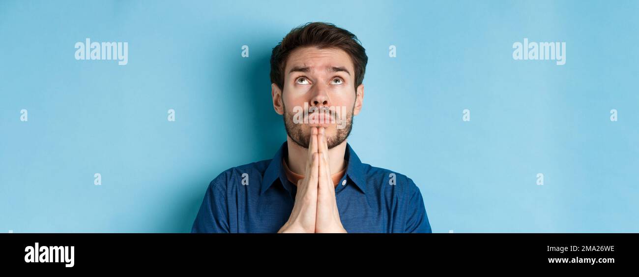 Close up shot of hopeful guy pleading God, holding hands in begging ...