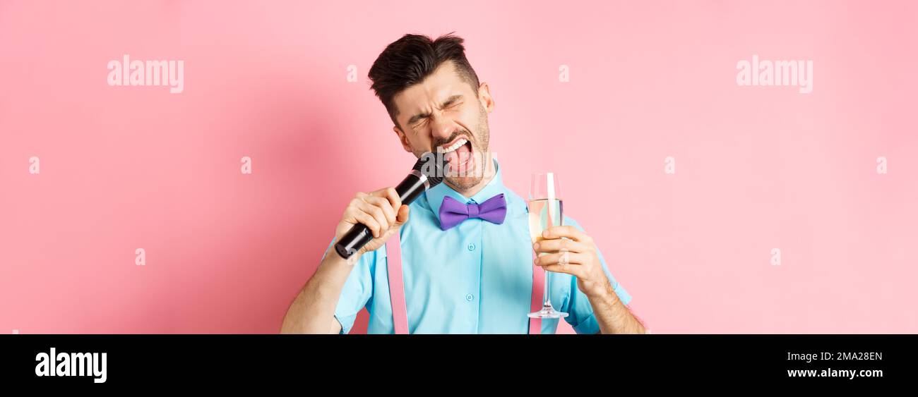 Party and festive events concept. Drunk funny guy singing in microphone ...