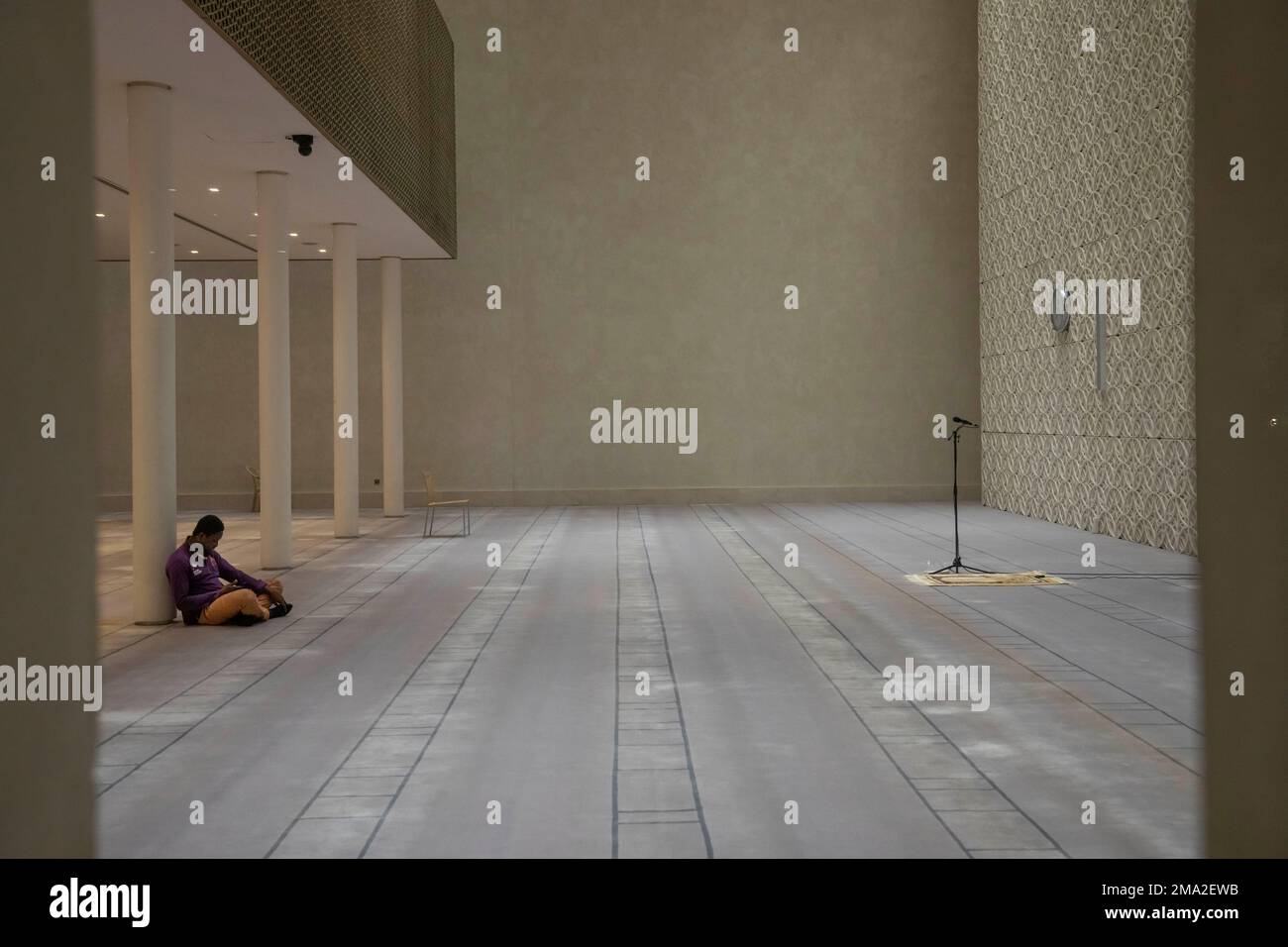 A migrant worker waits for evening prayer to begin, inside a mosque, in ...