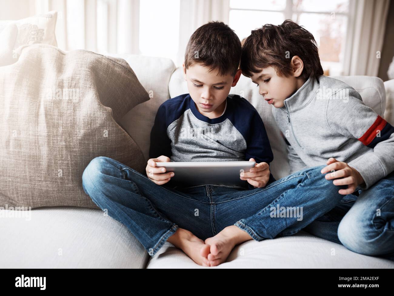 Sibling boys, tablet and couch for games, relax and digital app for ...