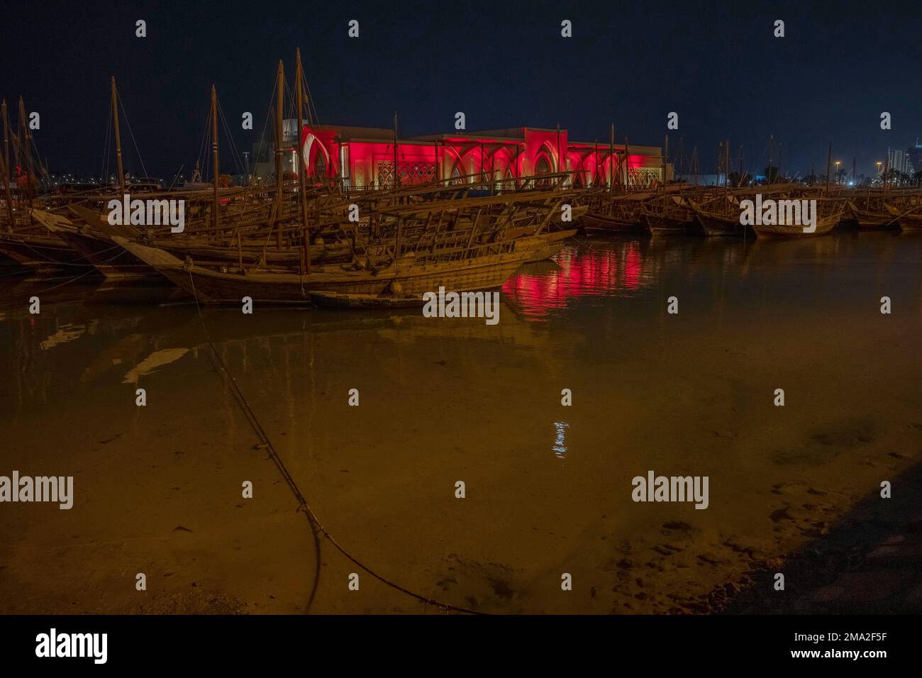 Traditional wooden boats are docked on the corniche in Doha, Qatar ...