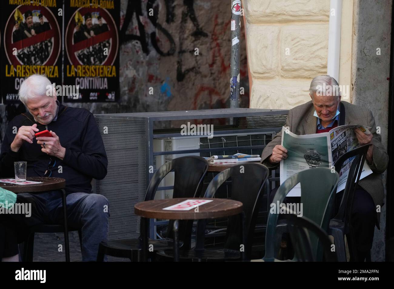 People enjoy their reading as they sit at a bar in Rome, Monday, Oct ...