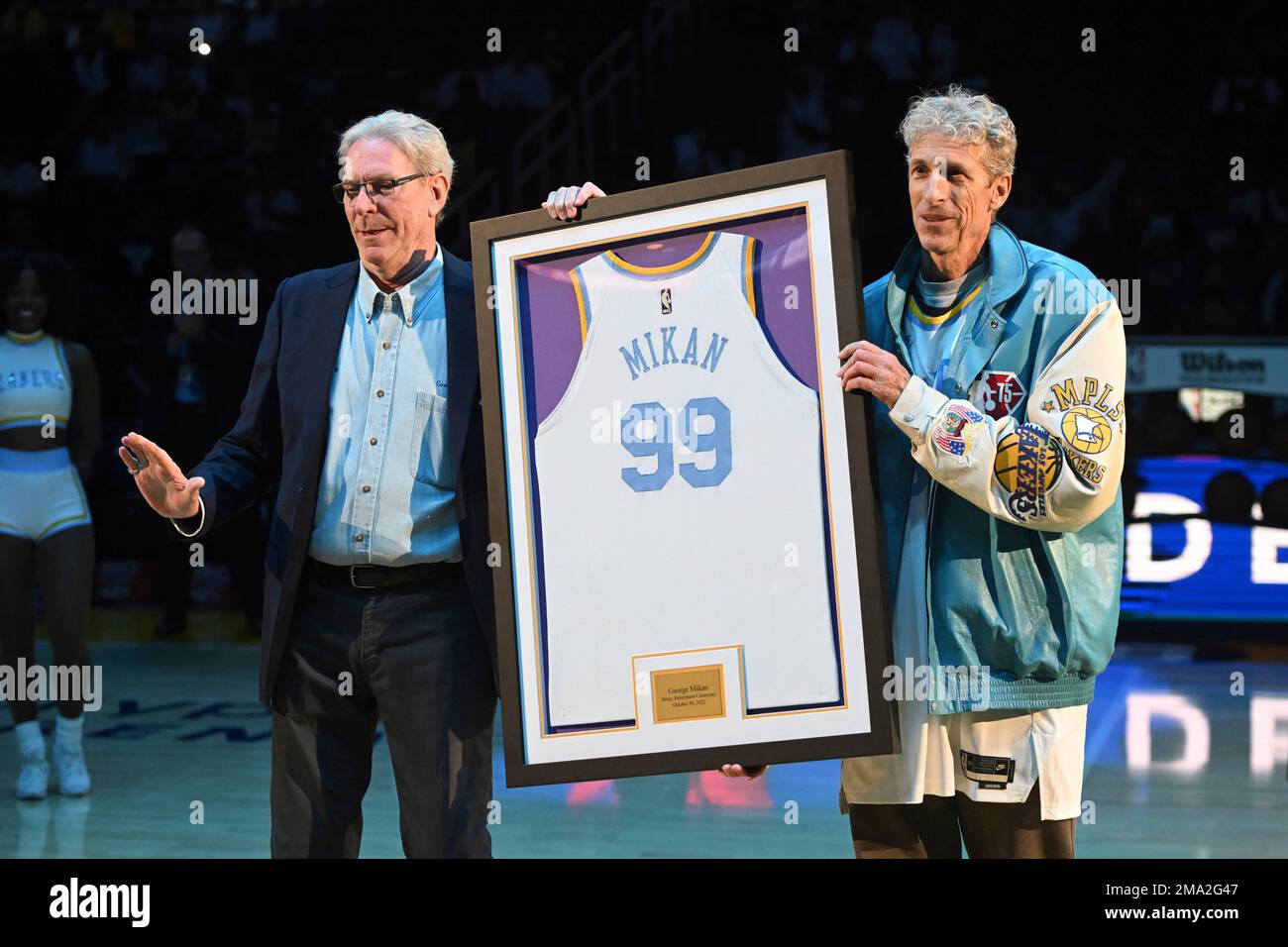Patrick Mikan, left, and Michael Mikan, hold the jersey of their father ...