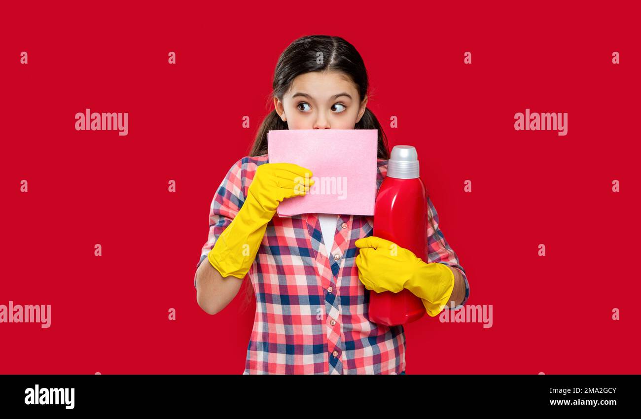 girl with softener detergent hiding behind duster in studio. girl with ...