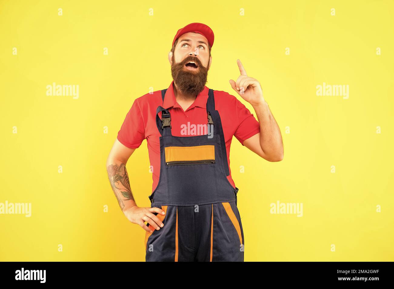 inspired bearded man mechanic in work clothes on yellow background ...