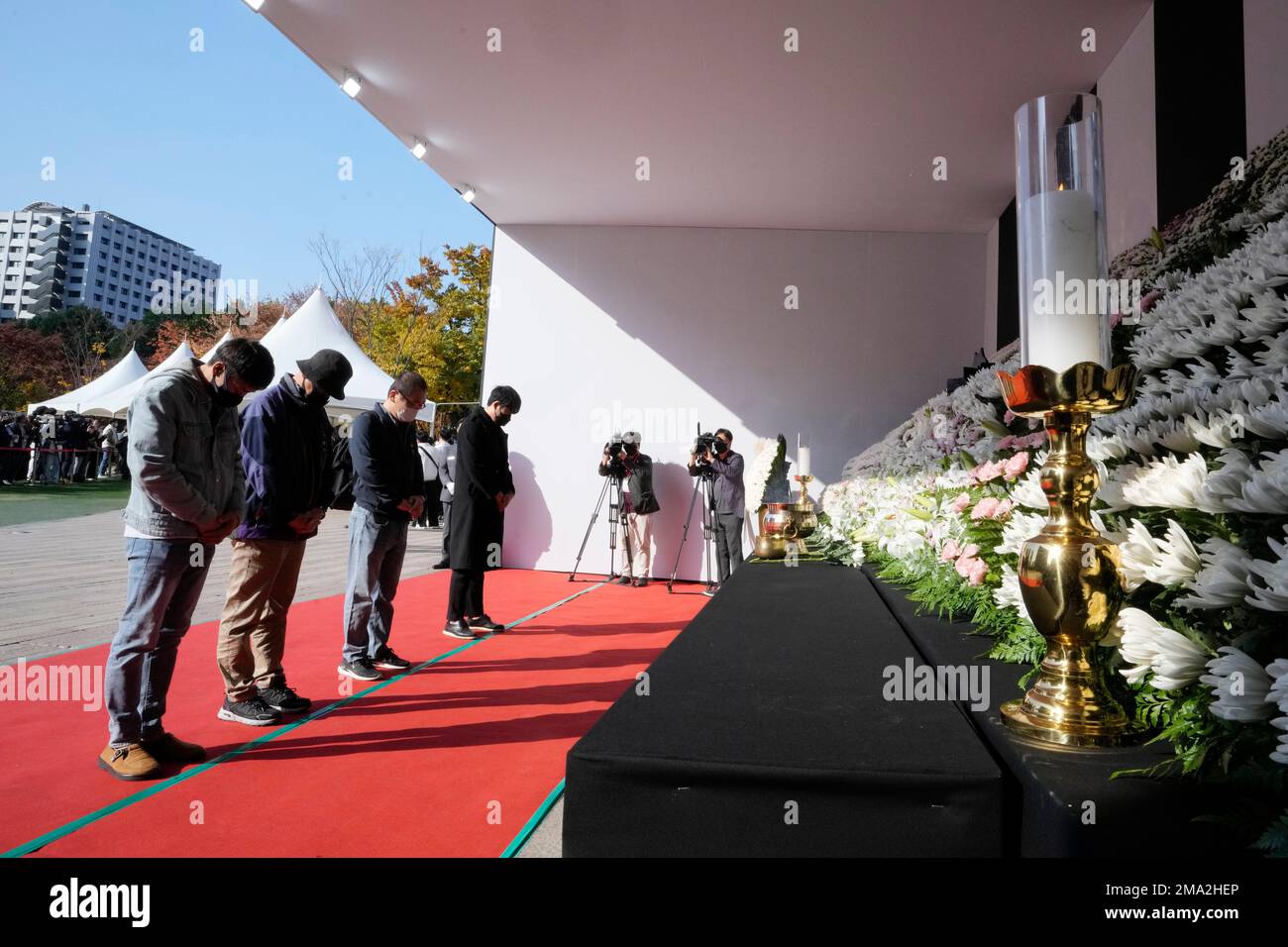 Mourners pay a silent tribute for victims of a deadly accident ...