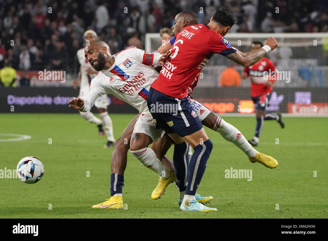 Lyon's Alexandre Lacazette and Lille's Jose Fonte vie for the ball ...