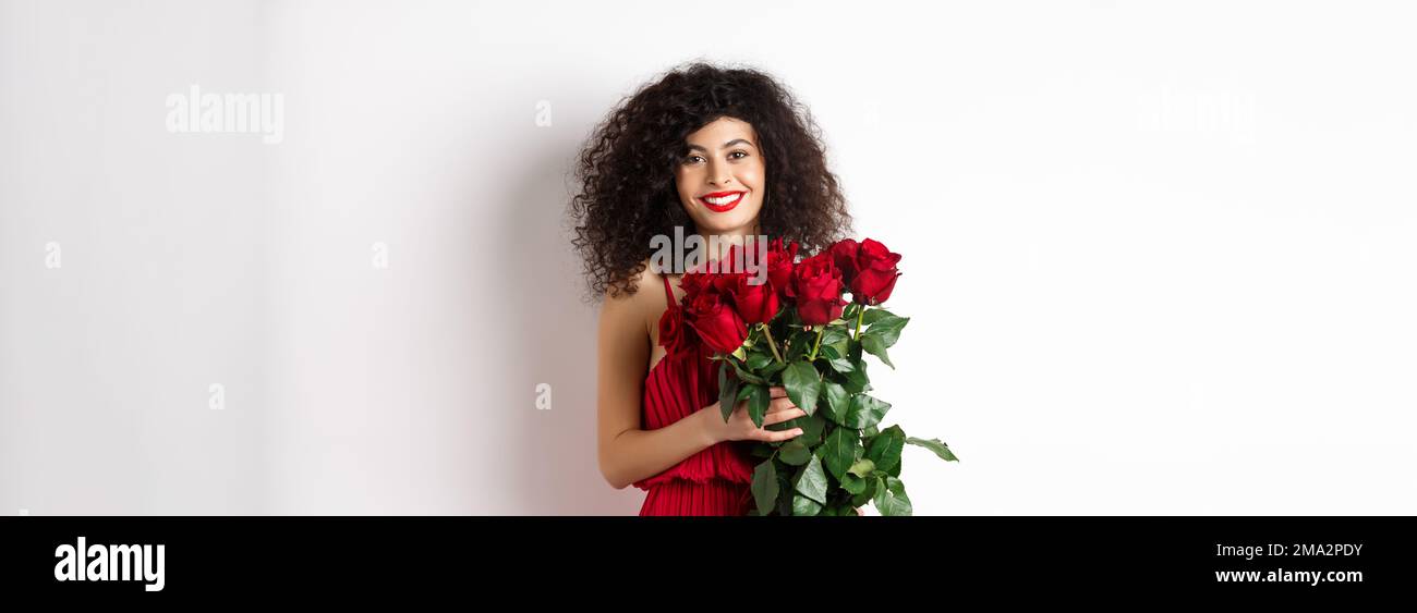 Gorgeous caucasian woman in red evening dress receiving bouquet of ...
