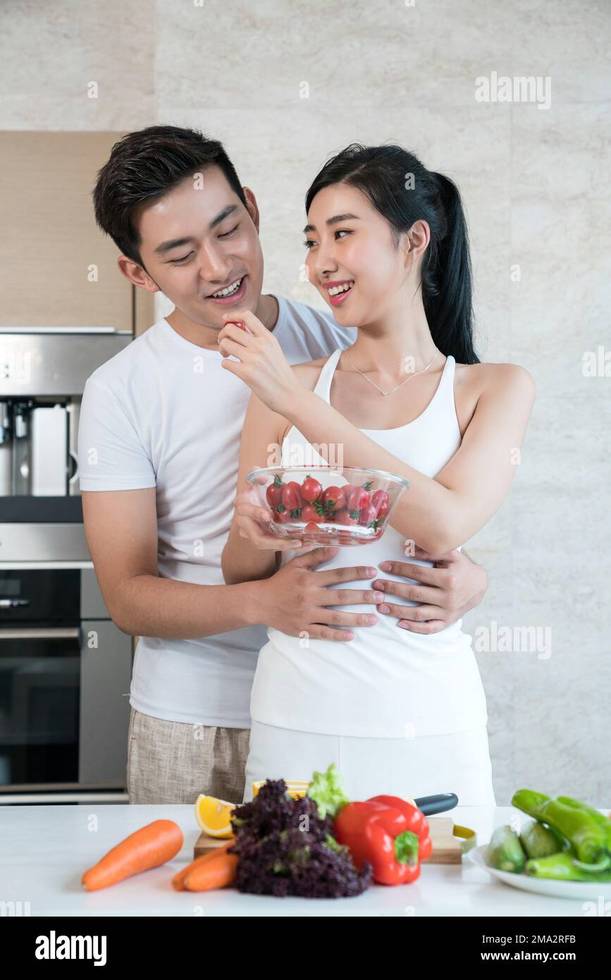 Young couples in the kitchen cooking Stock Photo - Alamy