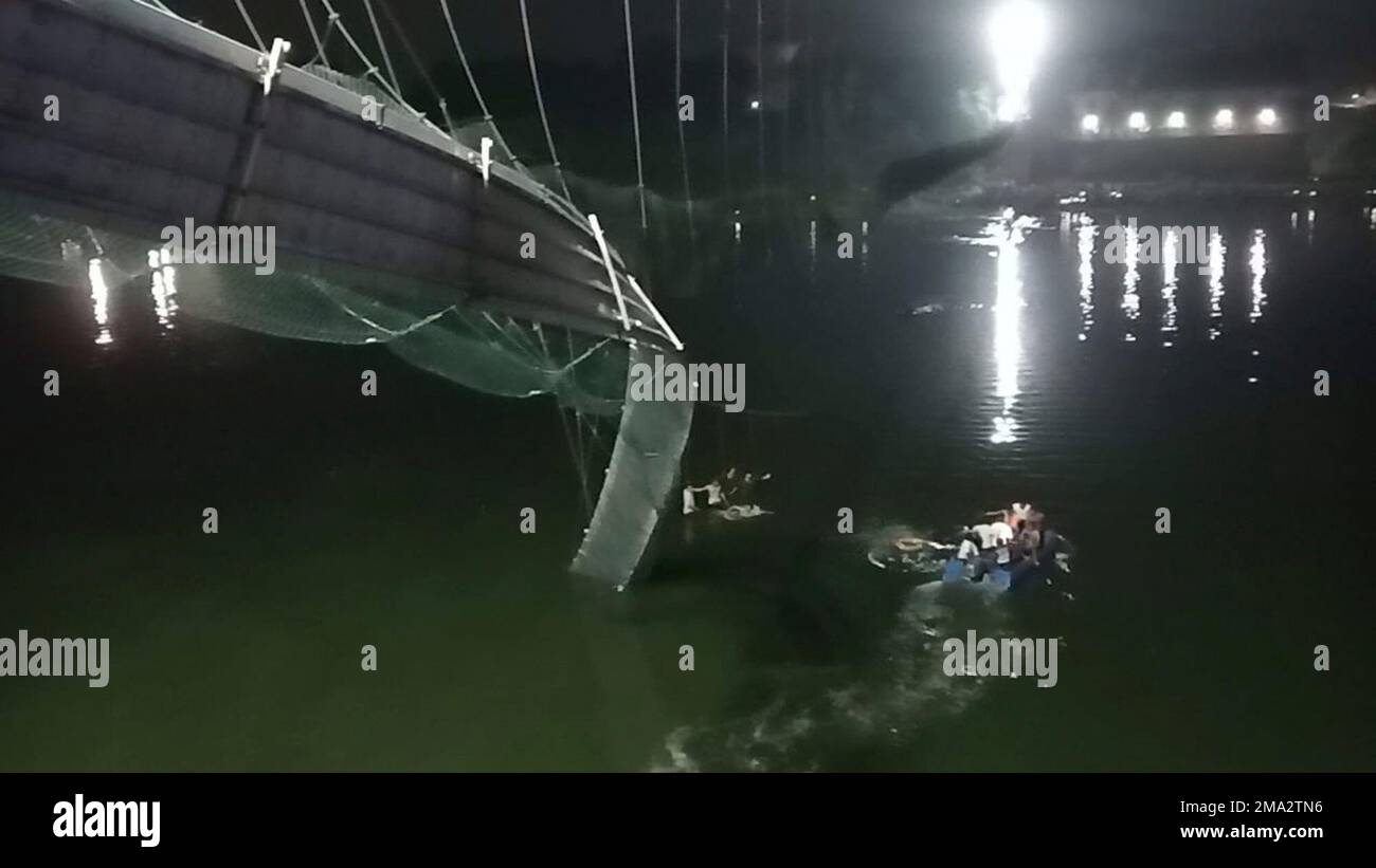 Rescuers on boats search in the Machchu river next to a cable bridge ...