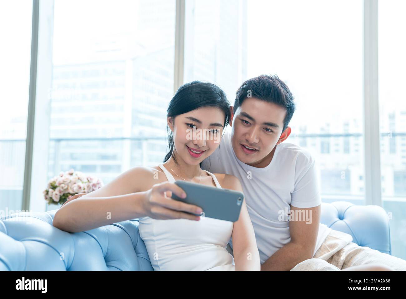 Young couples in the use of mobile phones on the sofa Stock Photo - Alamy