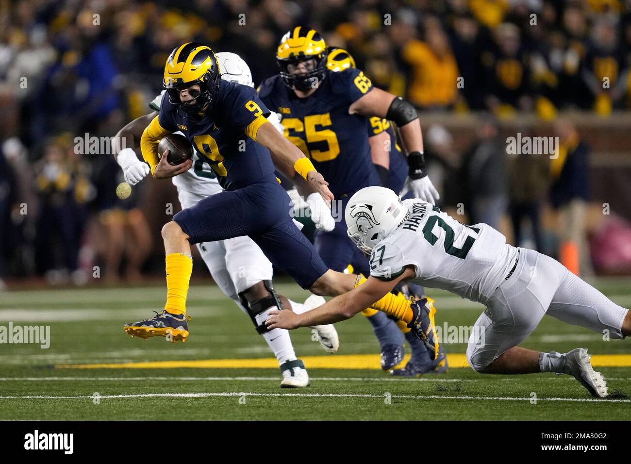 Michigan quarterback J.J. McCarthy (9) runs from Michigan State ...